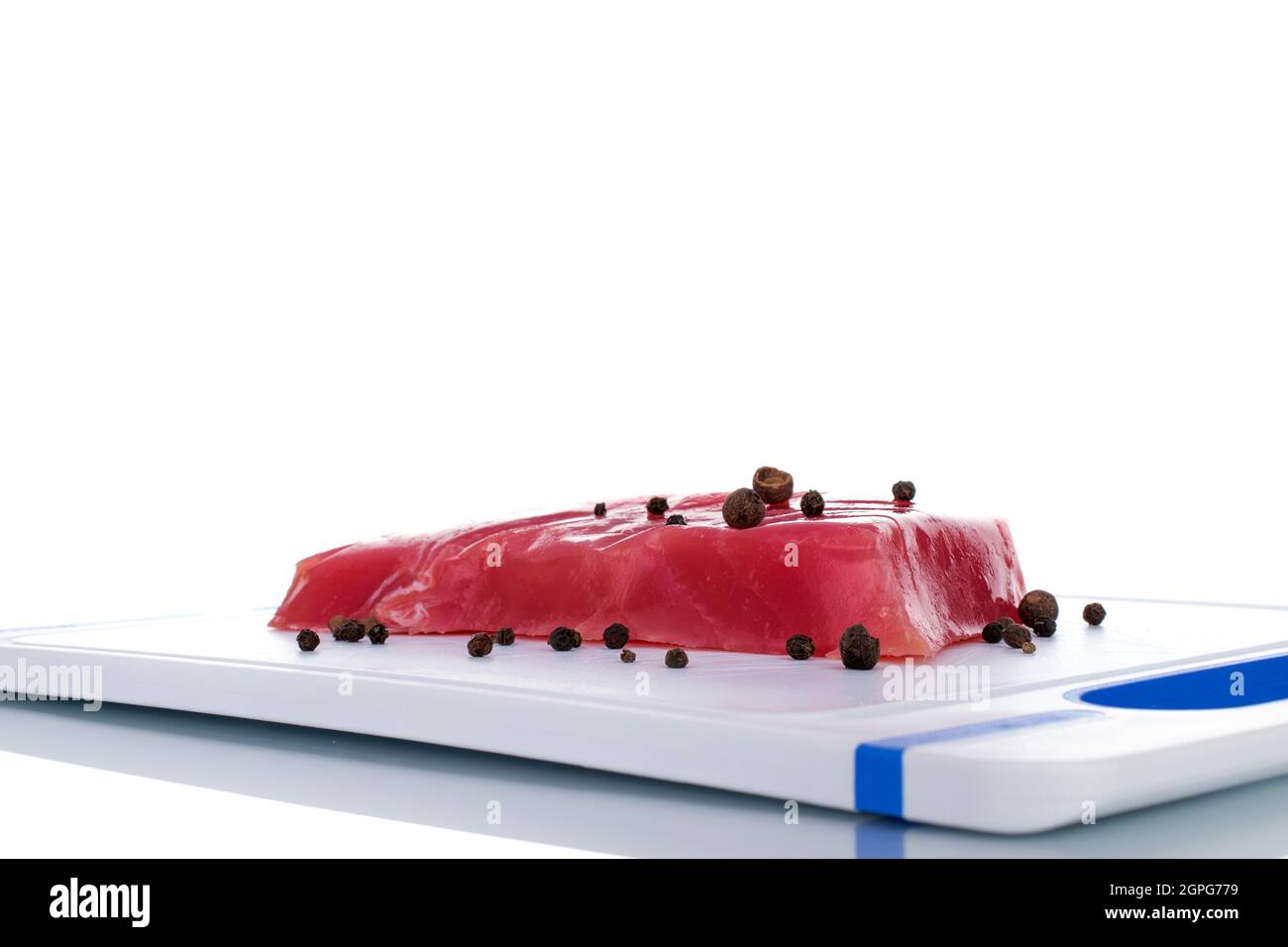 One piece of slightly salted tuna meat on a cutting board, close-up ...