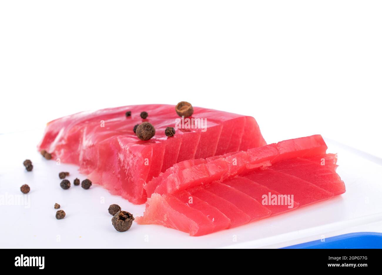 One piece of slightly salted tuna meat on a cutting board, close-up ...