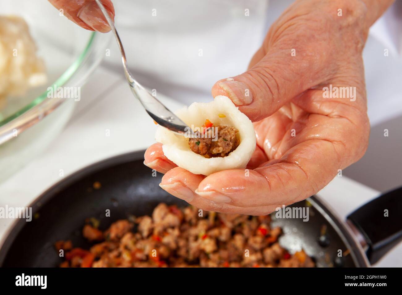 Preparation of a traditional Colombian fried stuffed yucca dumplings ...