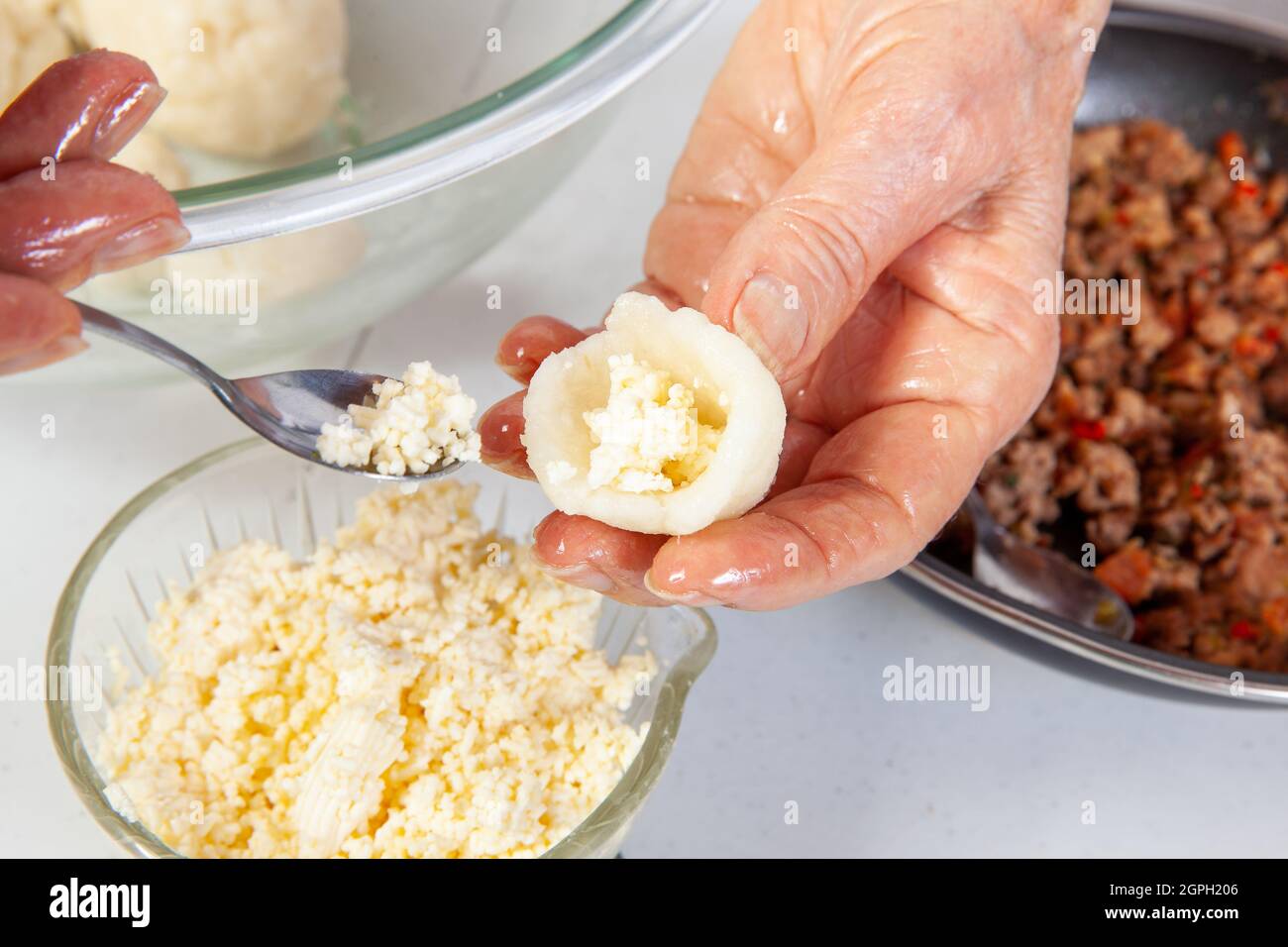 Preparation of a traditional Colombian fried stuffed yucca dumplings ...