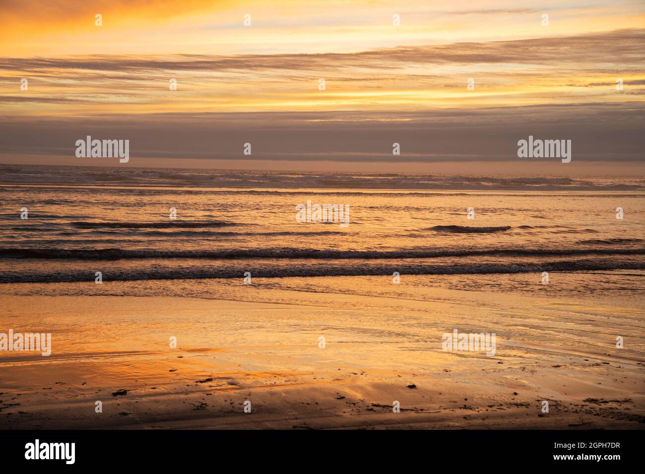 Sunset on the beach with waves Stock Photo - Alamy