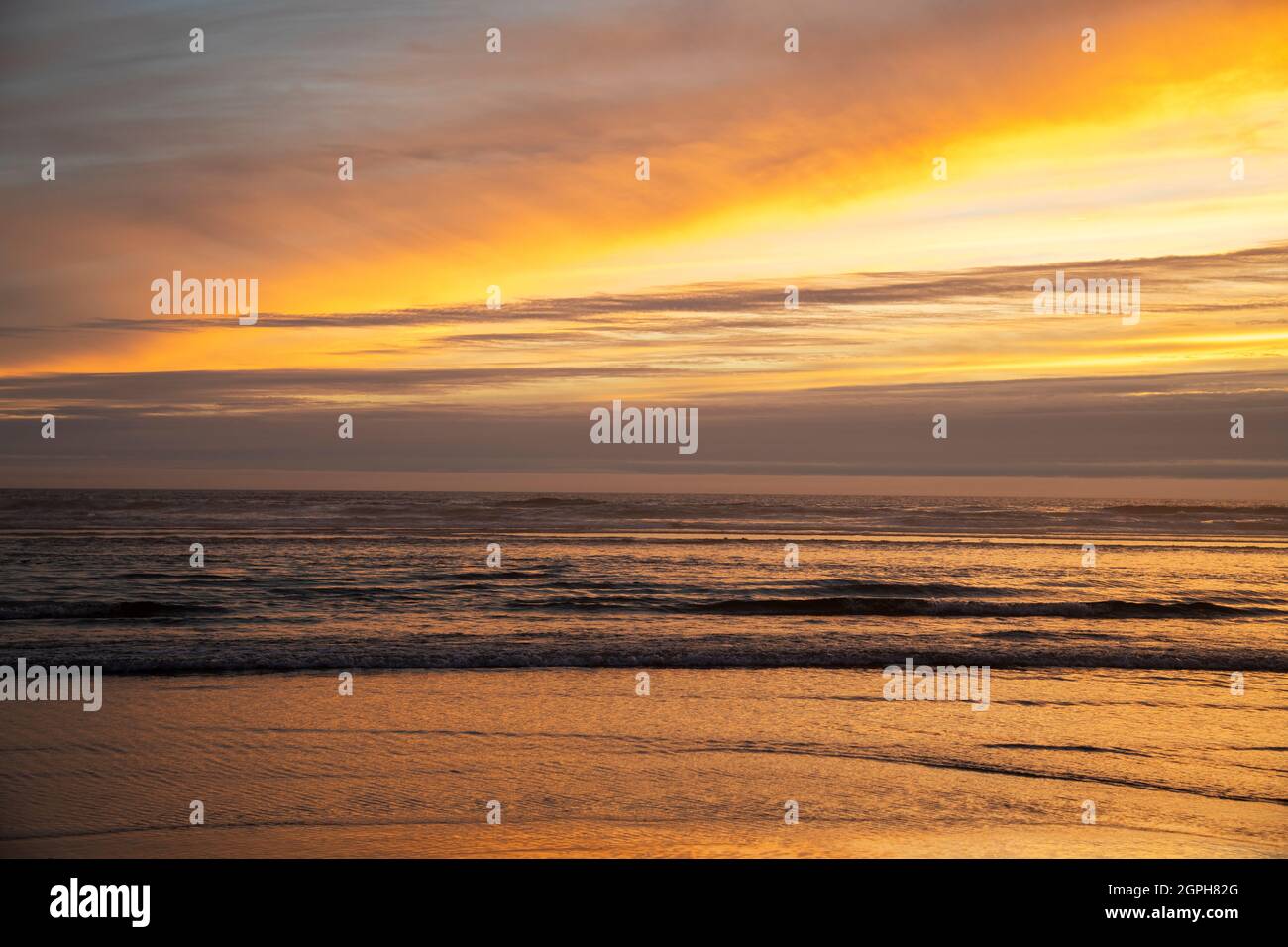 Sunset on the beach with waves Stock Photo - Alamy