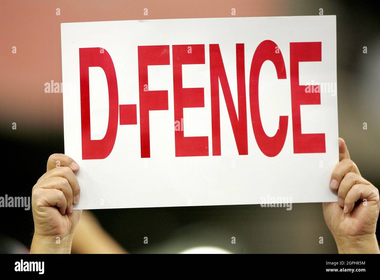 A sports fan holds up a sign that says defense to inspire the team ...