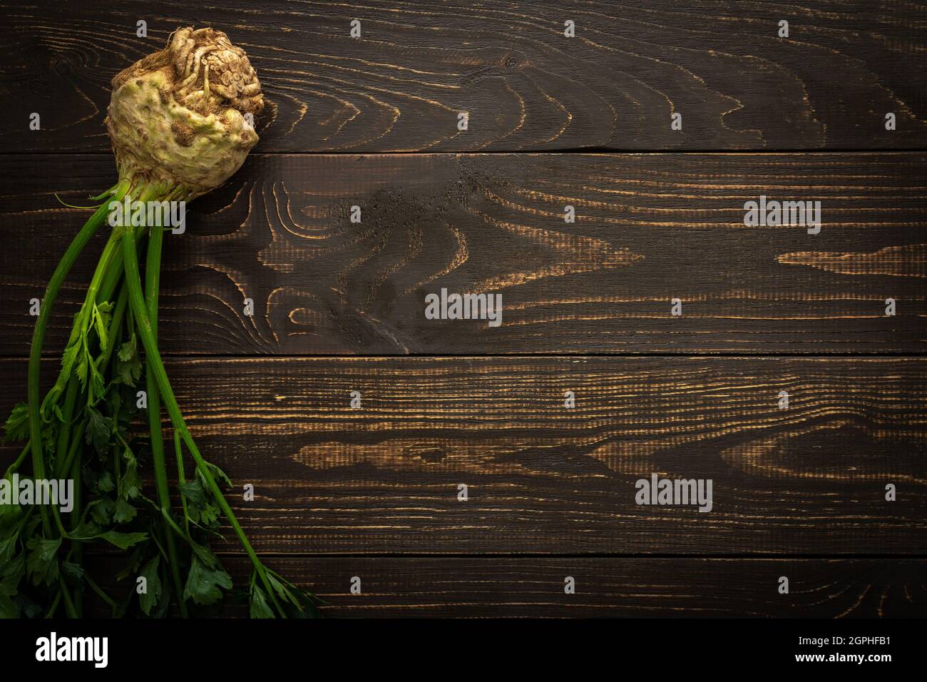 Root vegetable celera with green leaves on a wooden background, farm ...