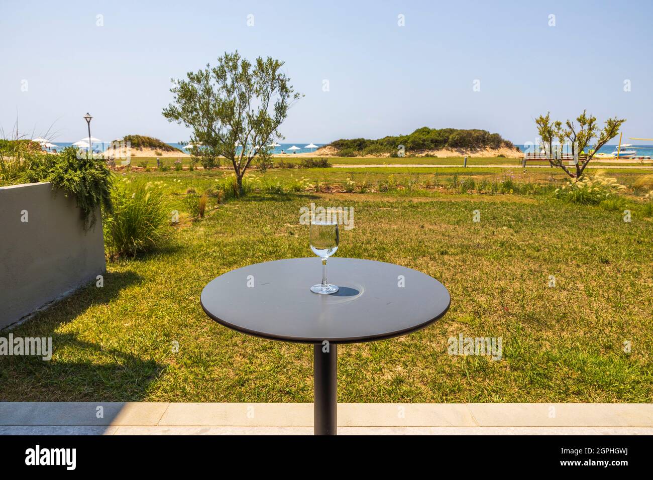 Beautiful view of water glass on table on patio with sea view. Greece ...