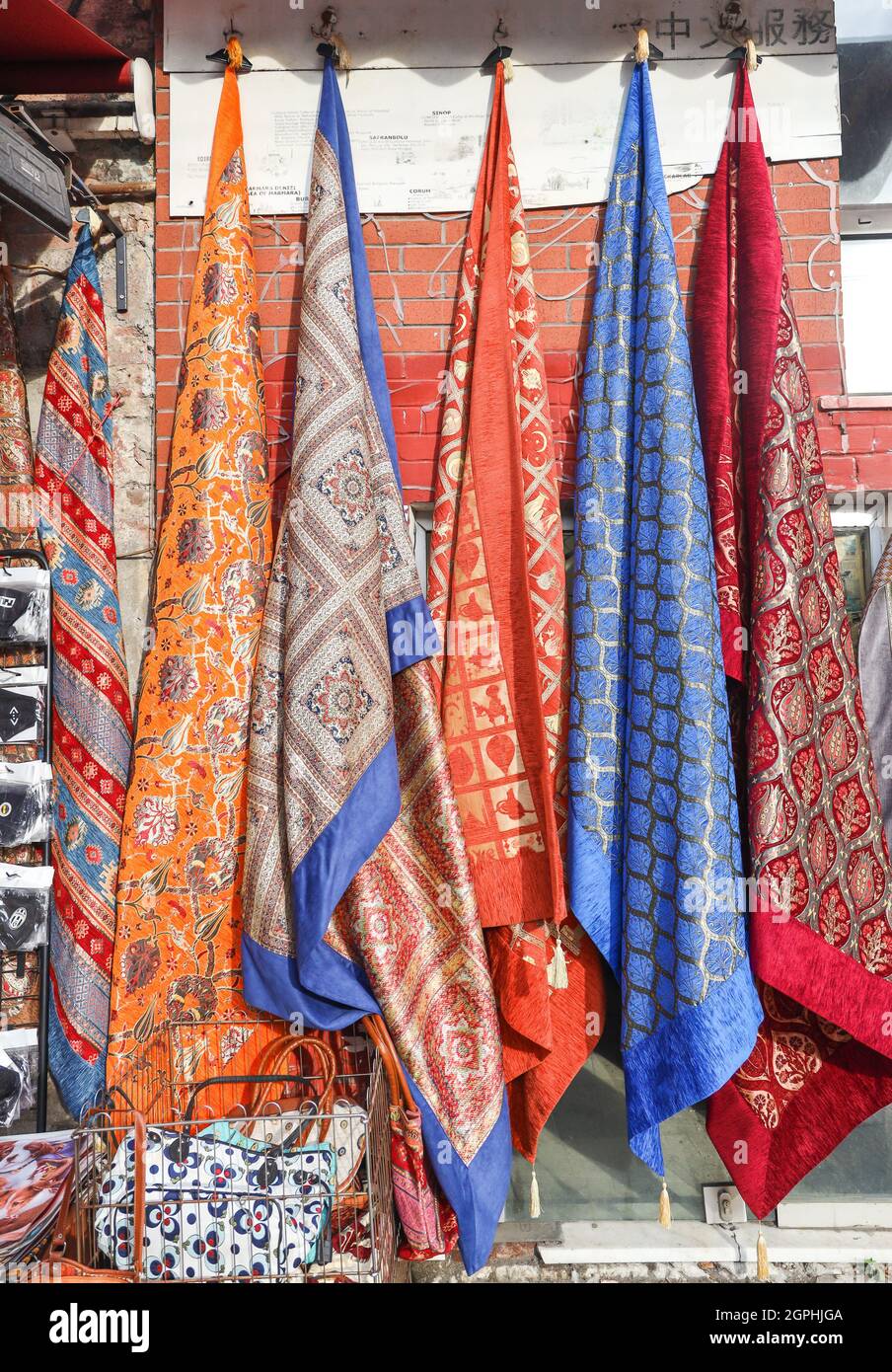 Colorful traditional silk tulle covers hang on the wall in the market ...