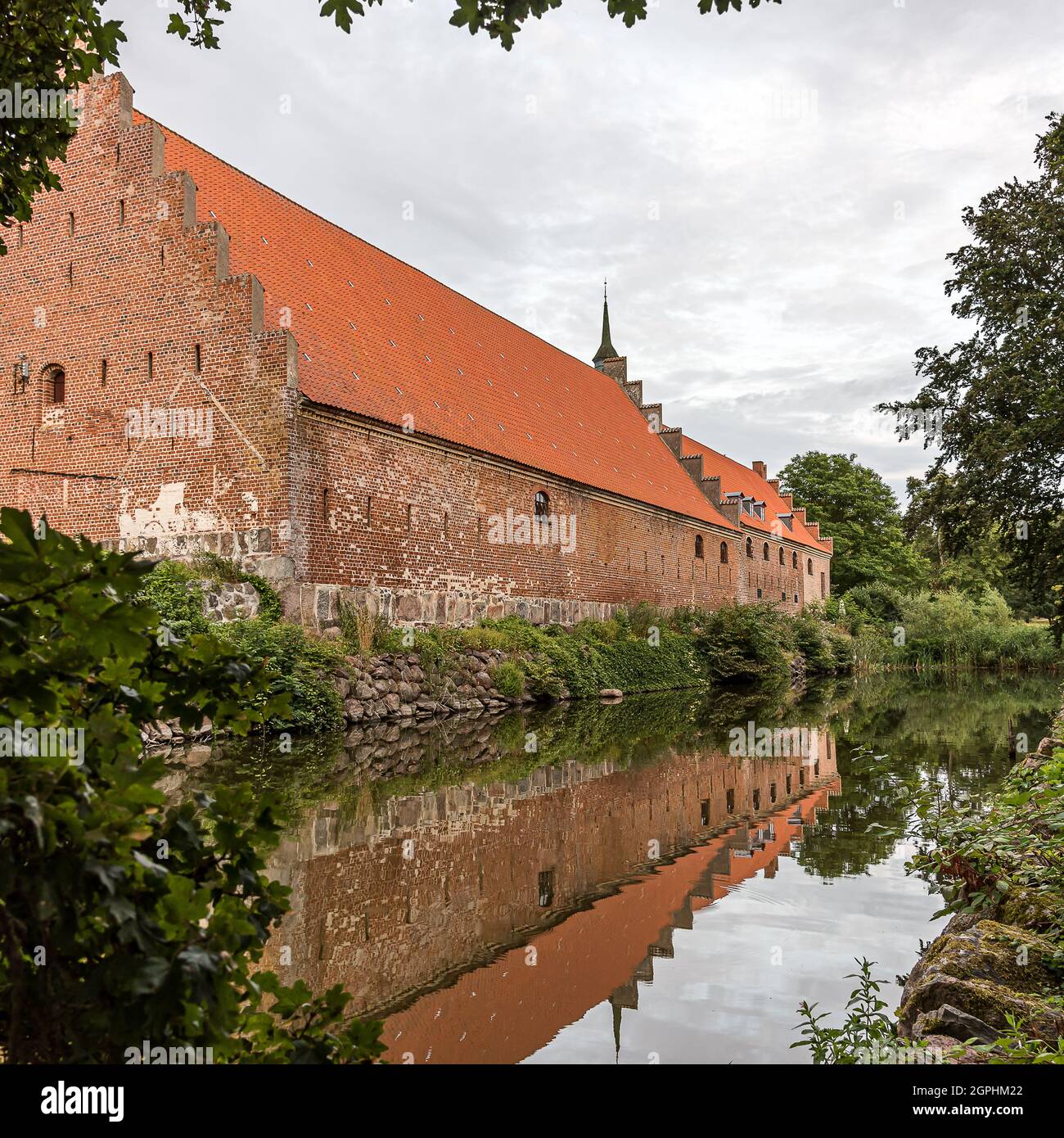 the big manors of Holsteinborg Castle reflecting in the moat, Denmark ...