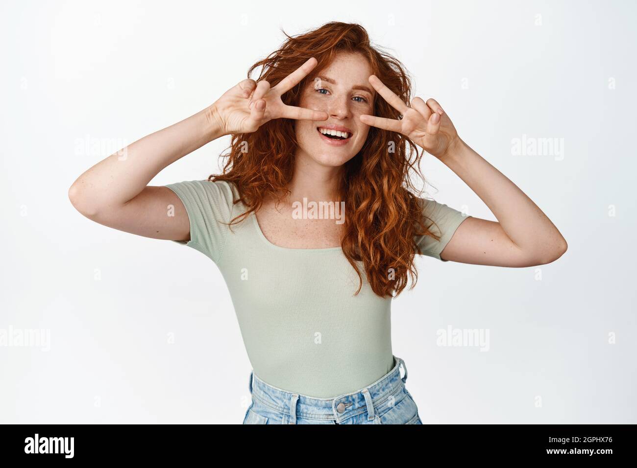 Beautiful ginger girl shows peace signs near eyes, clean natural face ...