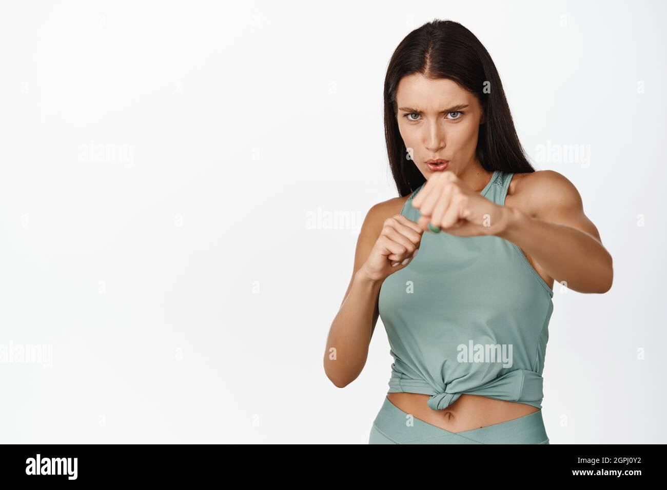 Serious and confident female boxer, shadow boxing, fighting on ring ...