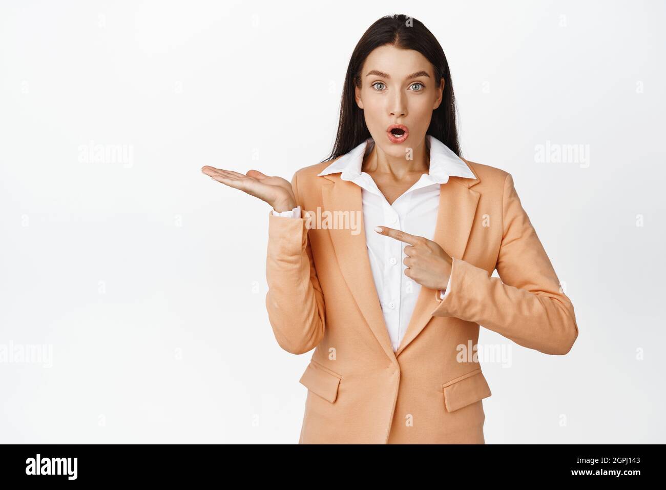 Woman in business suit pointing at empty hand, showing object on palm ...