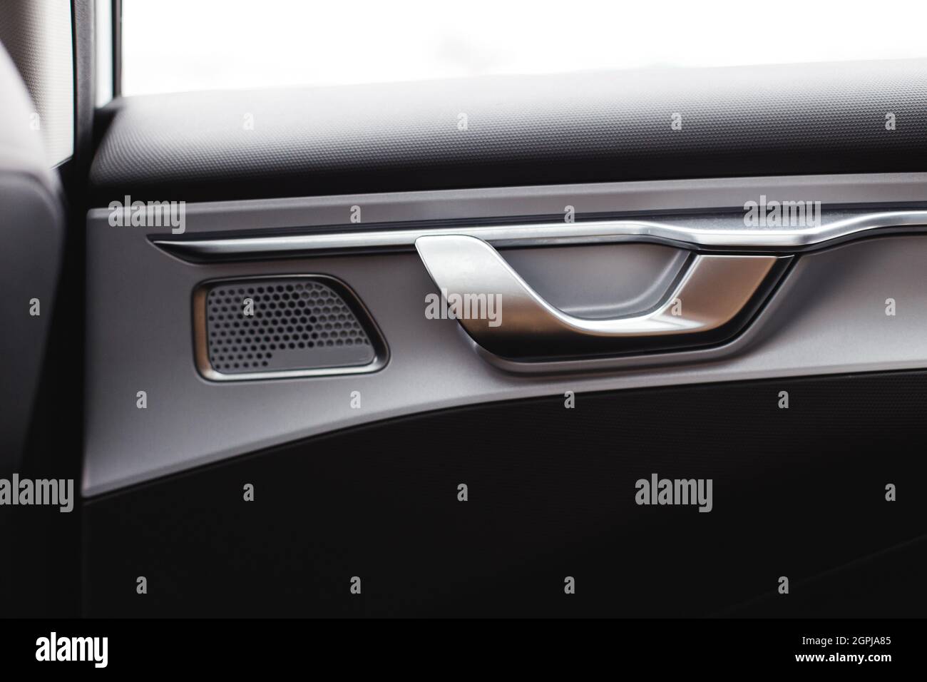 Inner door handle with lock unlock buttons, modern black car interior ...
