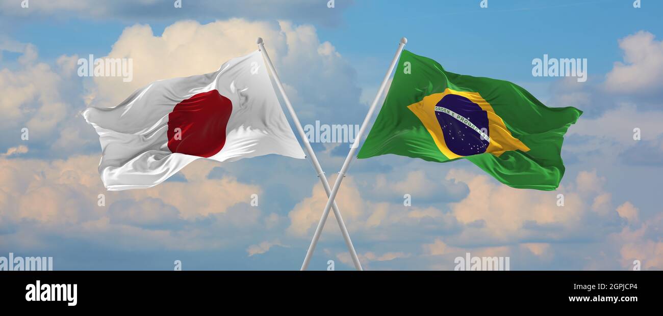 flags of Japan and Brazil waving in the wind on flagpoles against sky ...