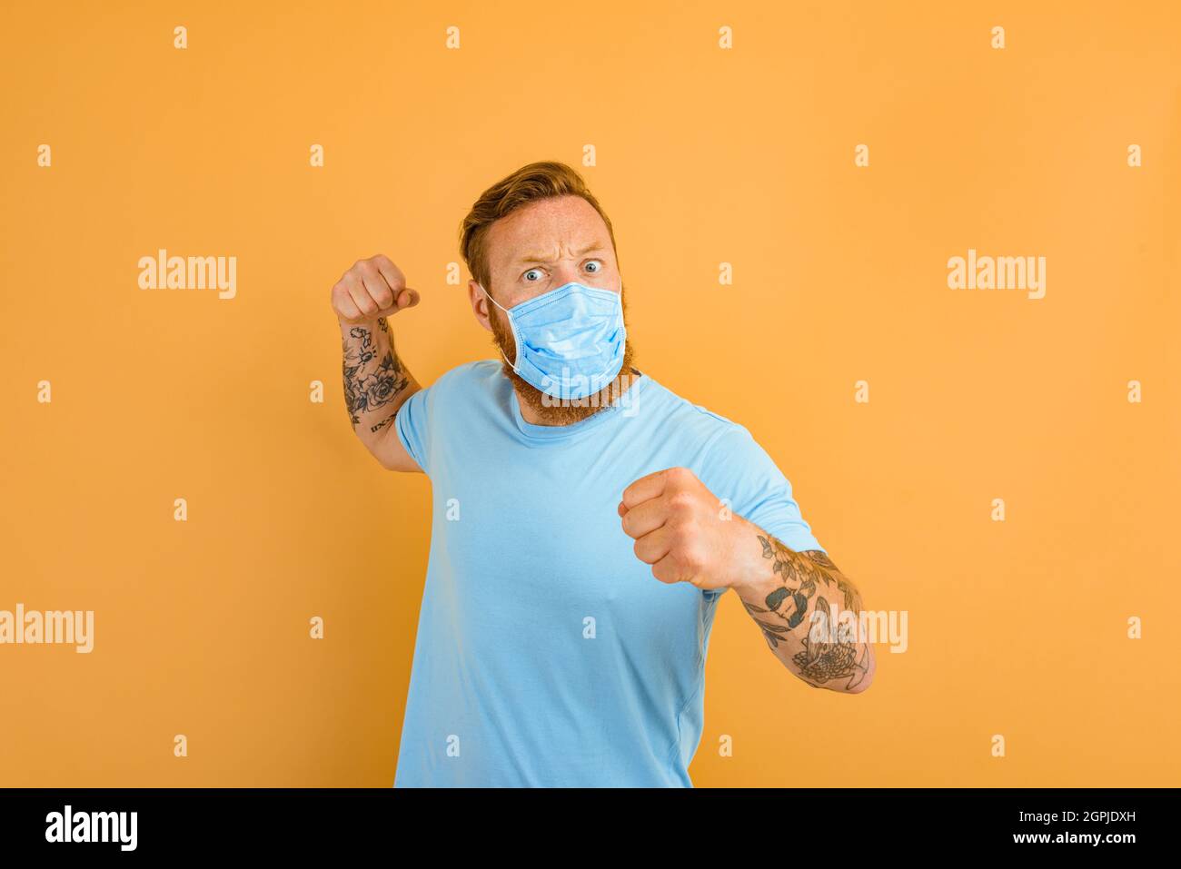 Angry man with beard, tattoo and mask for covid-19 wants to fight Stock ...