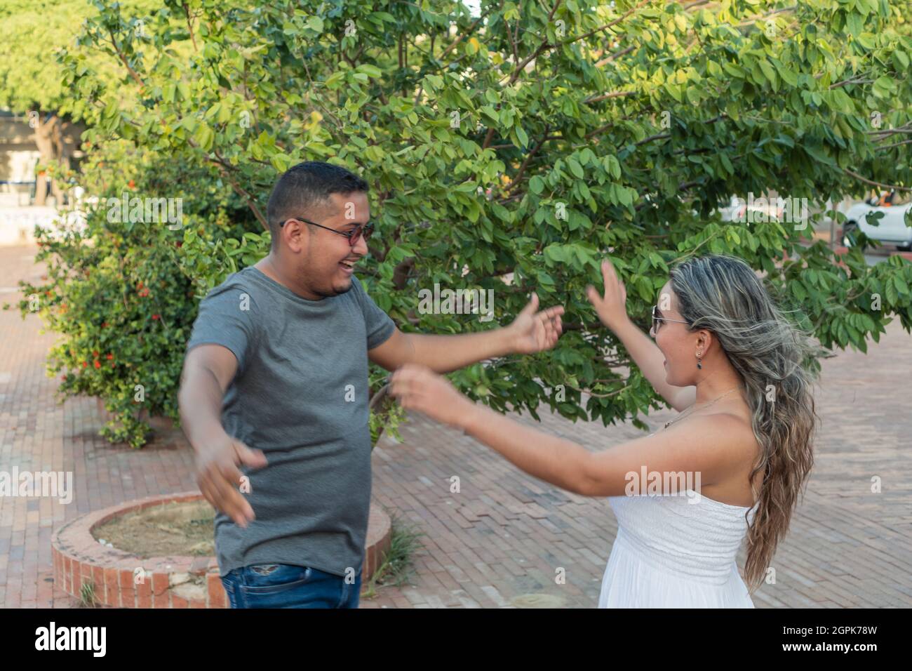 Two happy friends meeting and greeting on the street Stock Photo - Alamy