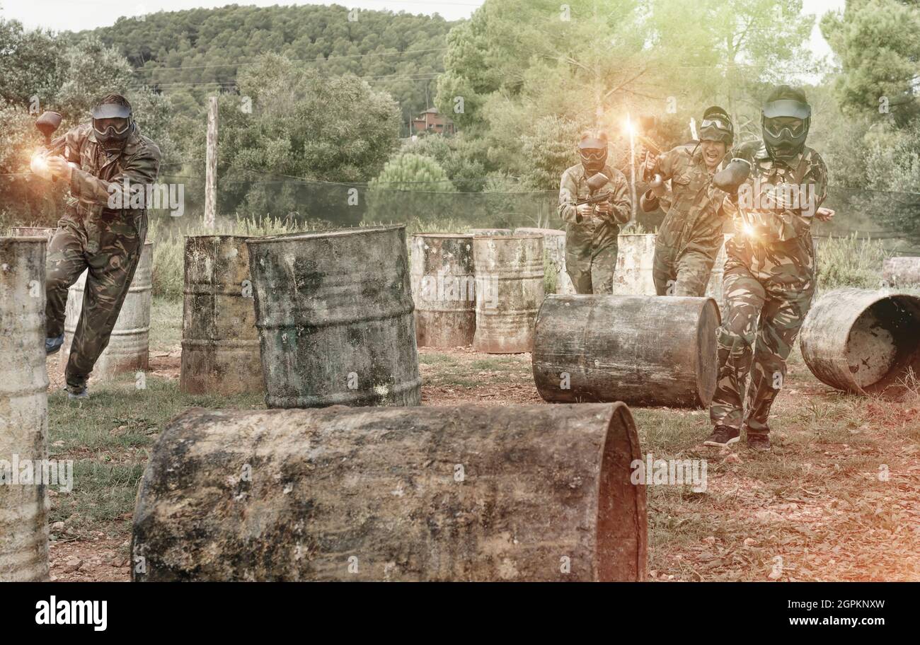 Paintball players aiming and shooting with guns Stock Photo - Alamy