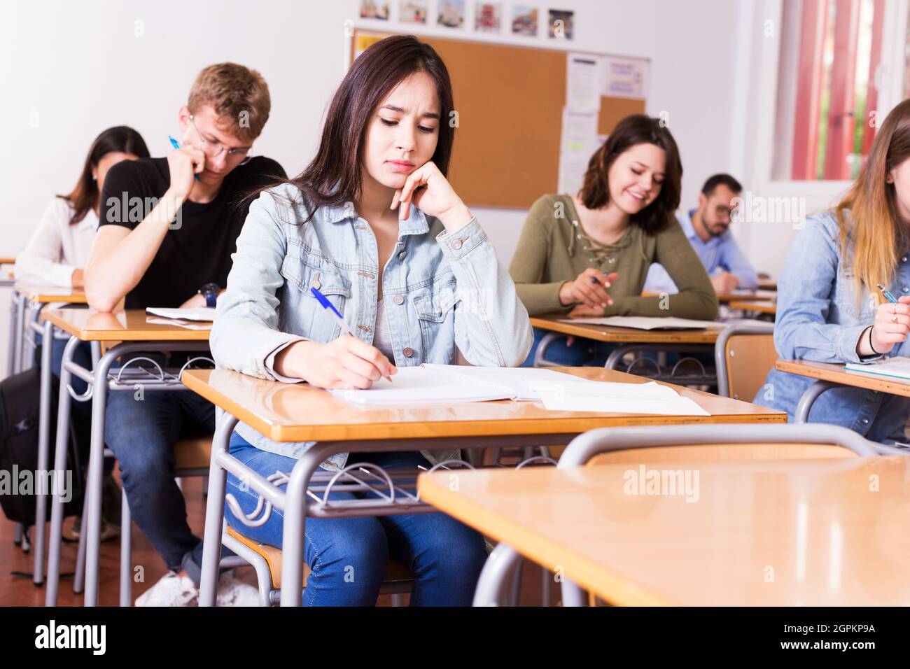 Girl writing test in classroom Stock Photo - Alamy