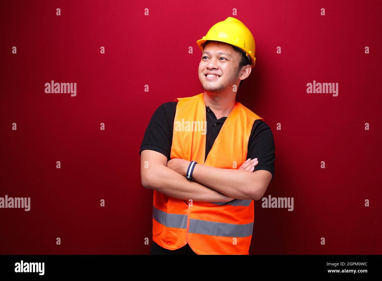Portrait of smiling young asian man worker isolated on red Stock Photo ...