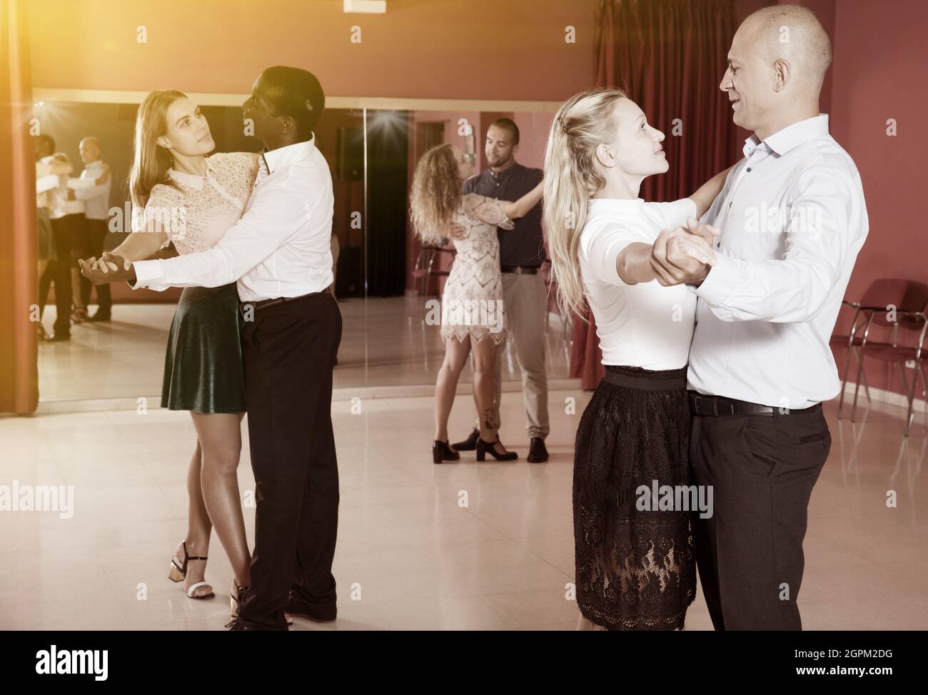 Positive people learning to dance classical dance together in dancing ...