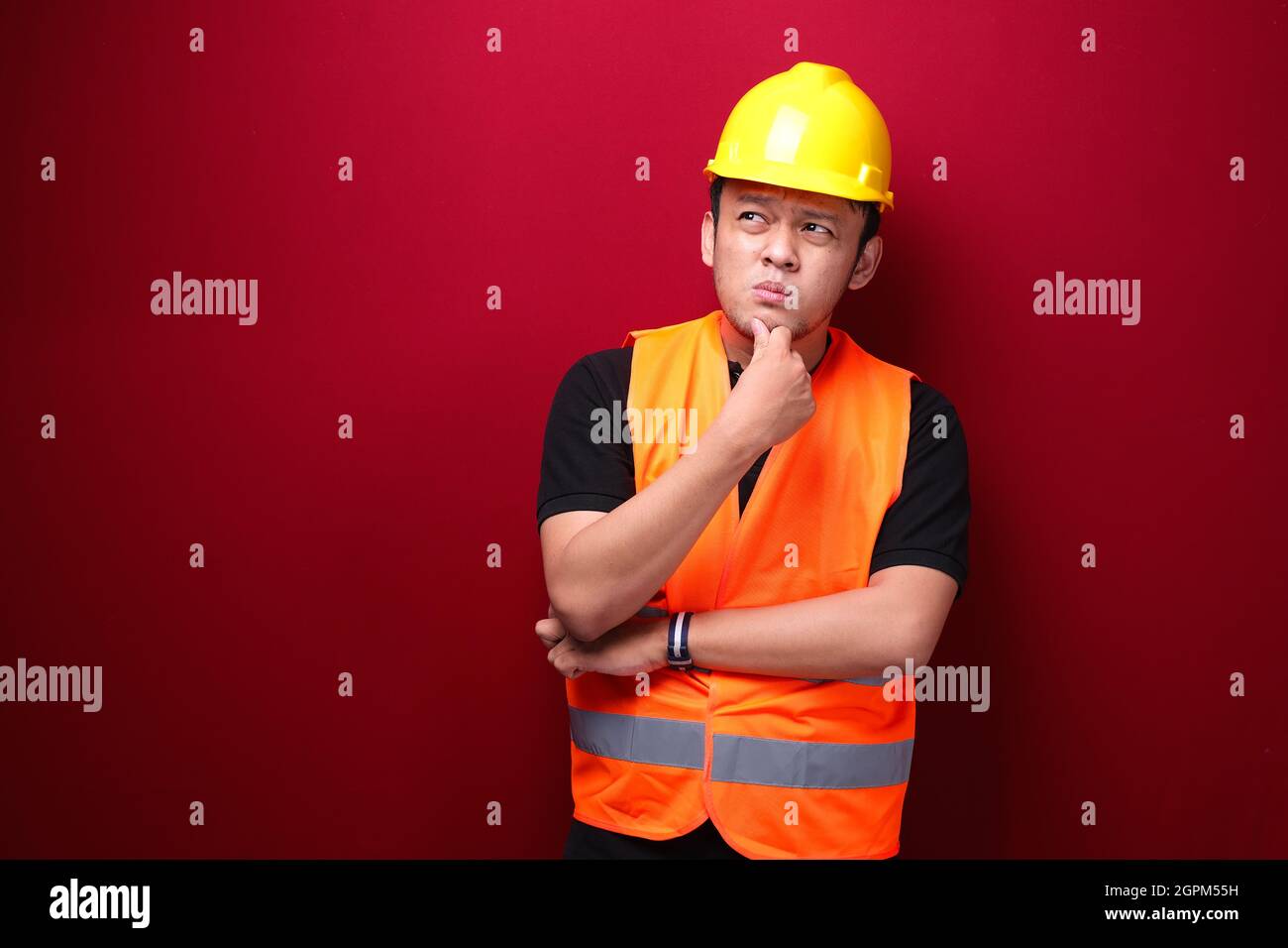 Thinking Young asian man worker is seriously think gesture on red ...