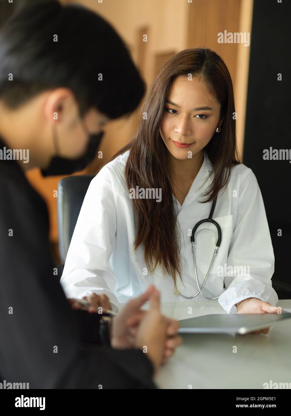 A serious young man patient consults with a female doctor about his ...
