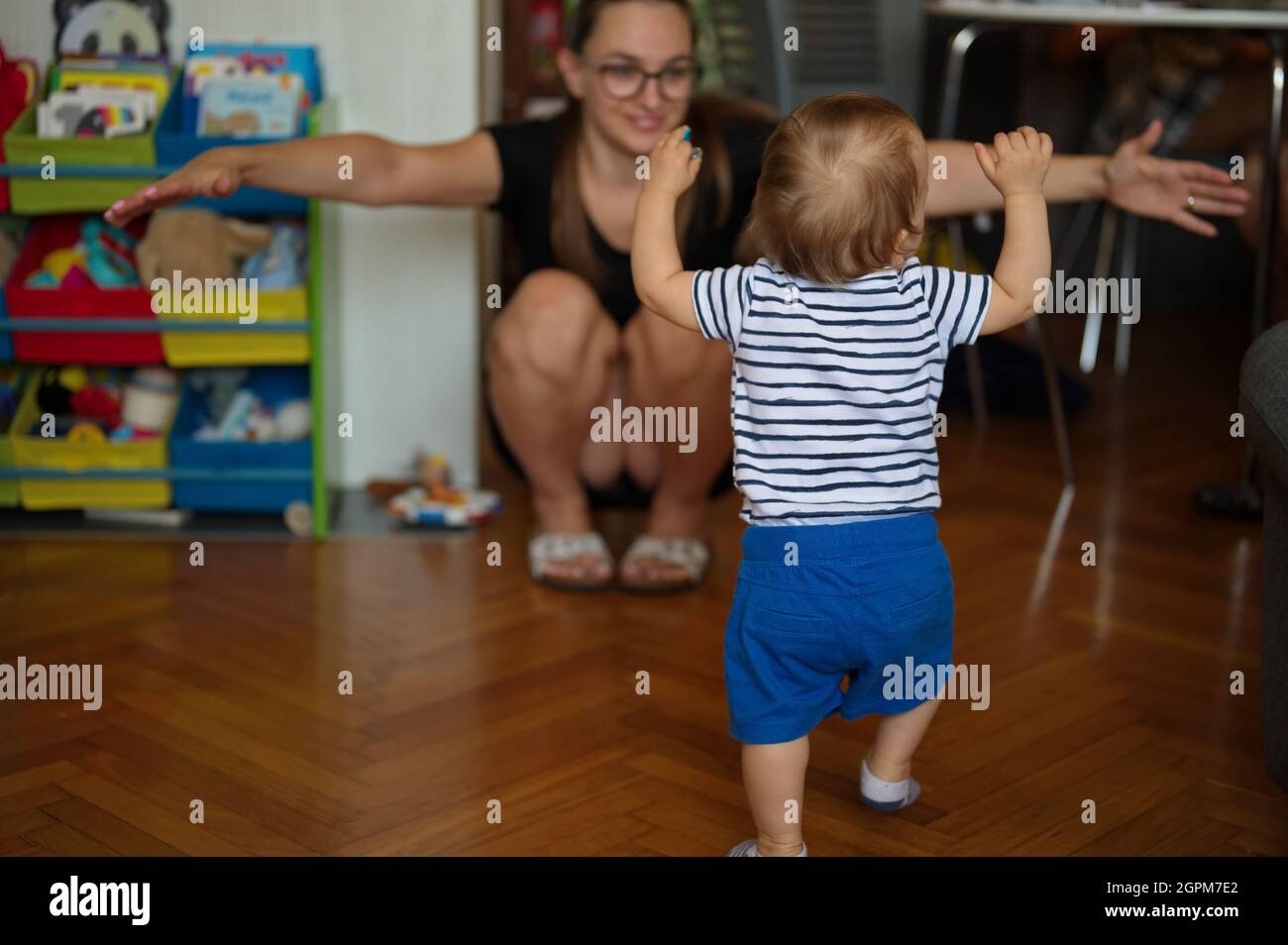 Adorable little baby boy taking his first steps Stock Photo - Alamy