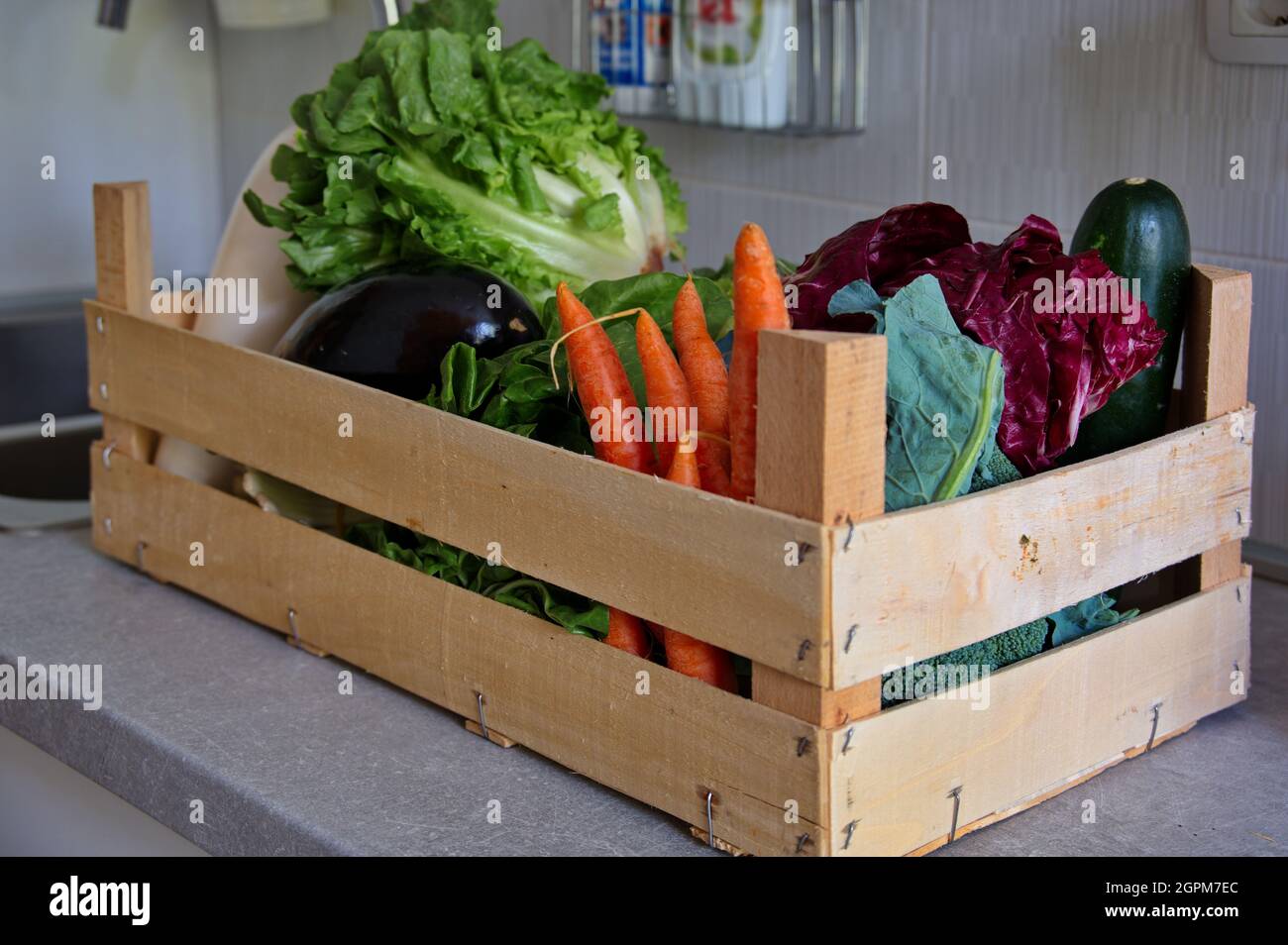 Healthy vegetables in wooden container on kitchen desk Stock Photo - Alamy