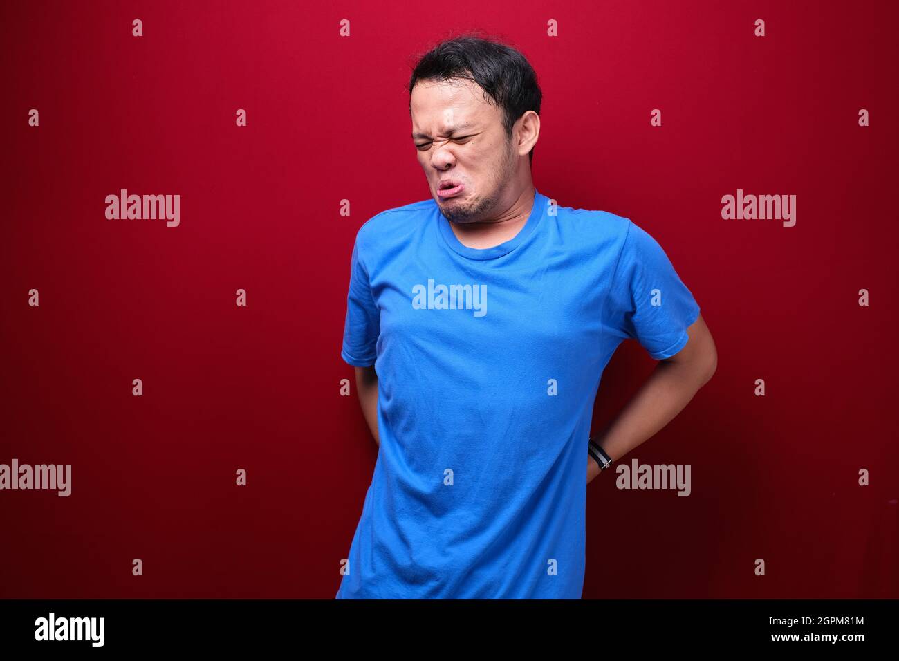 Sad and upset young asian man with serious pain in back man Stock Photo ...