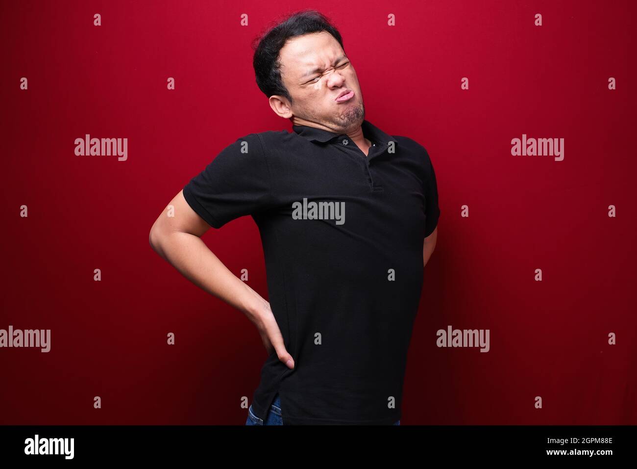 Sad and upset young asian man with serious pain in back man Stock Photo ...