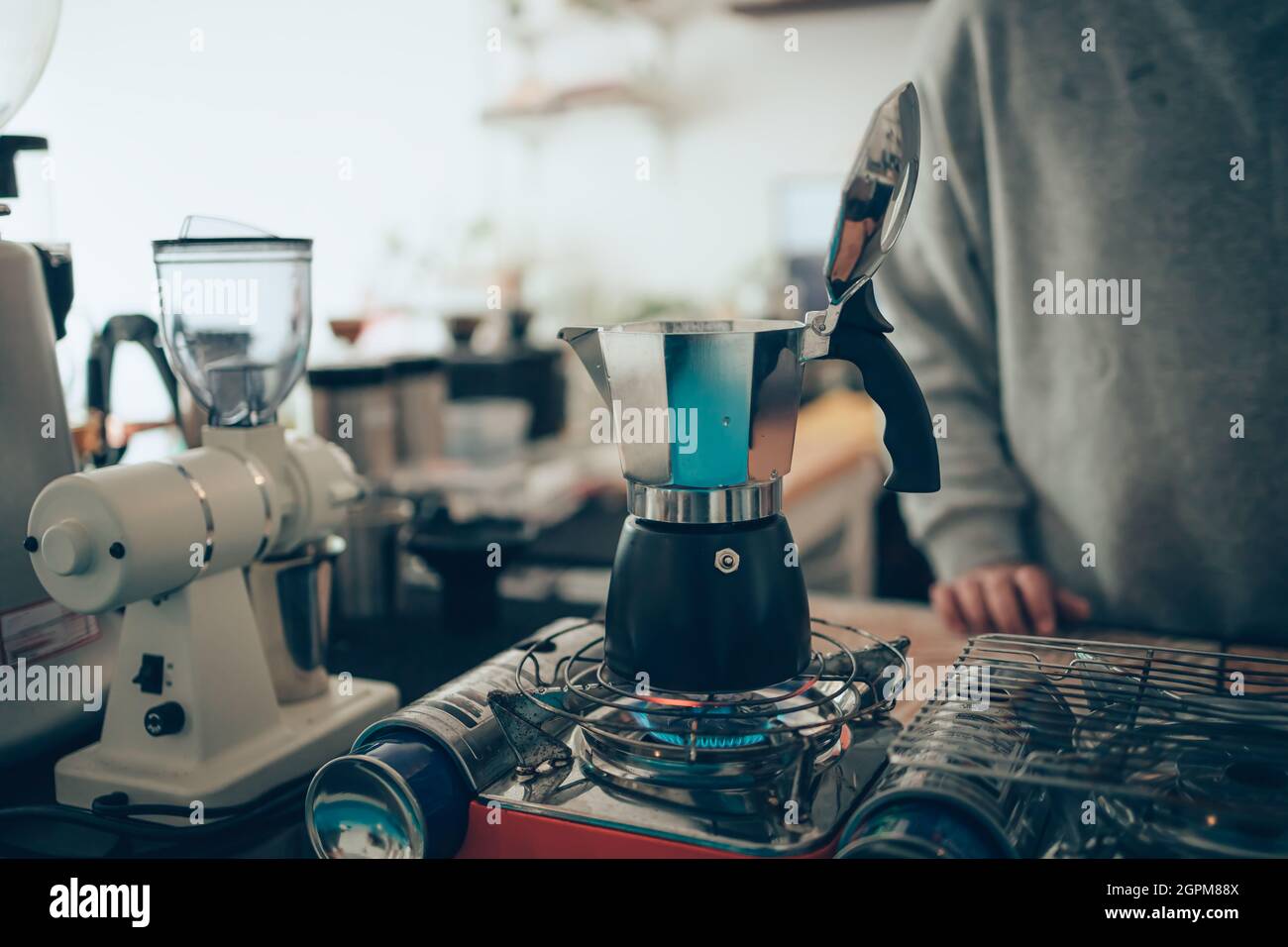 Brewing black moka coffee using moka coffee maker and boiling on stove ...