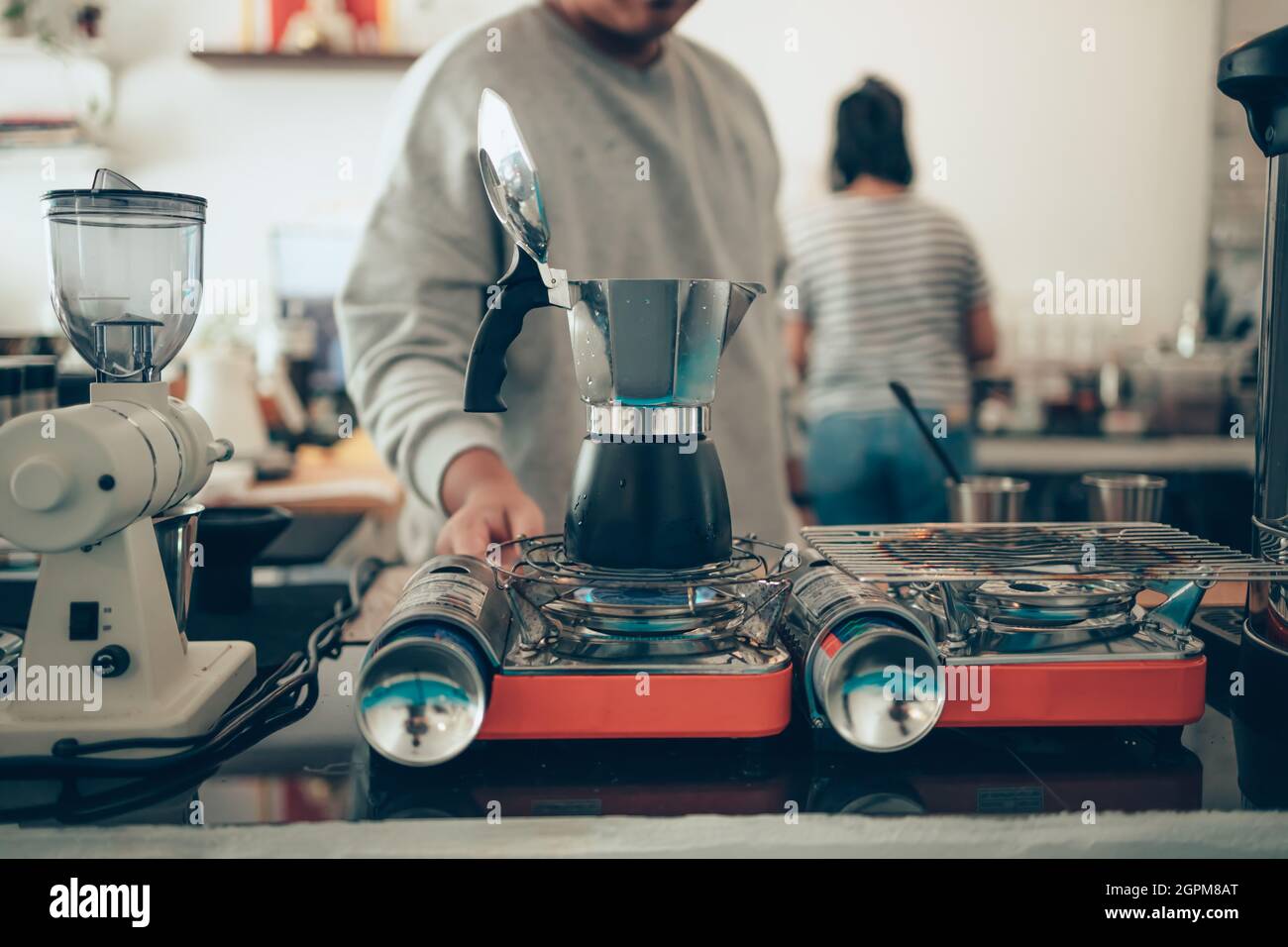 Brewing black moka coffee using moka coffee maker and boiling on stove ...