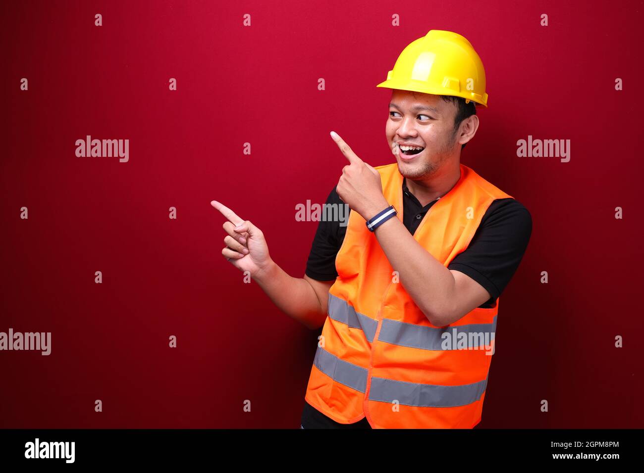 Smile and happy young asian man worker is with with hand point on empty ...