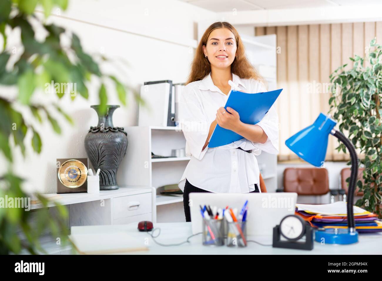 Confident young secretary takes important notes on a tablet in a office ...