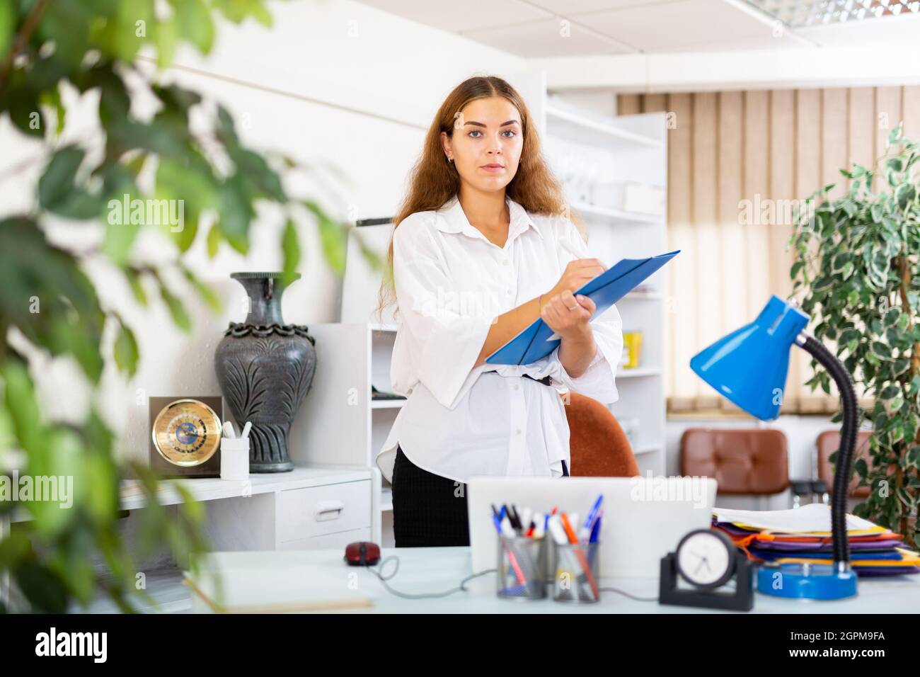 Confident young secretary takes important notes on a tablet in a office ...