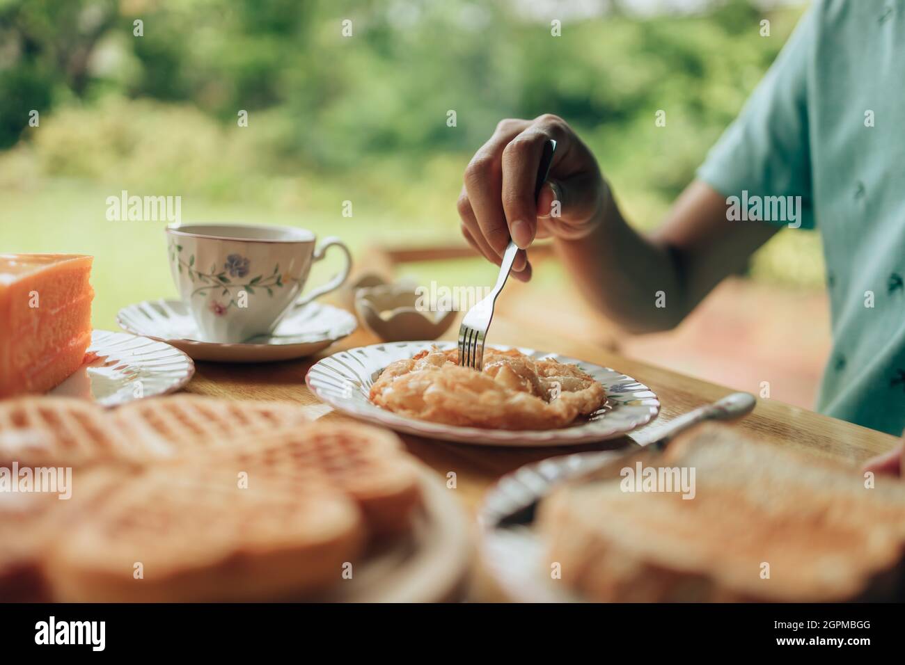 Hand use fork pick piece of fresh roti in plate. Roti and dessert ...