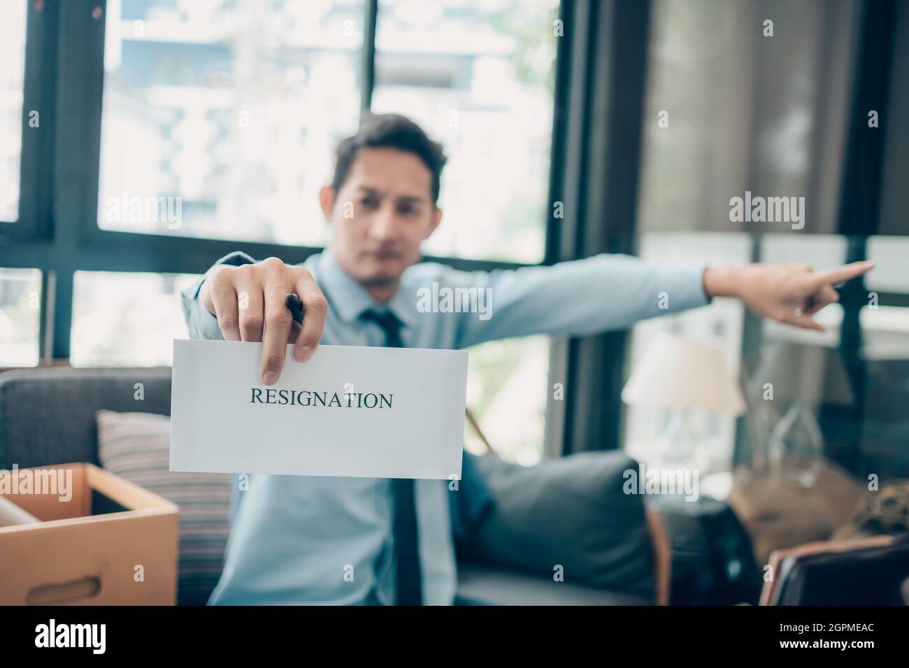A boss showing resignation letter to employer and hand sign " Get out ...