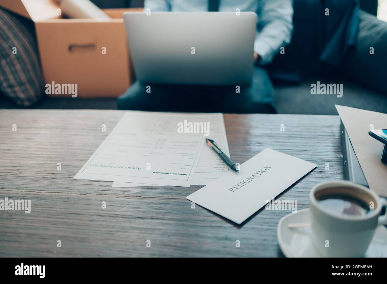 Employment Application form with pen and resignation letter on table ...