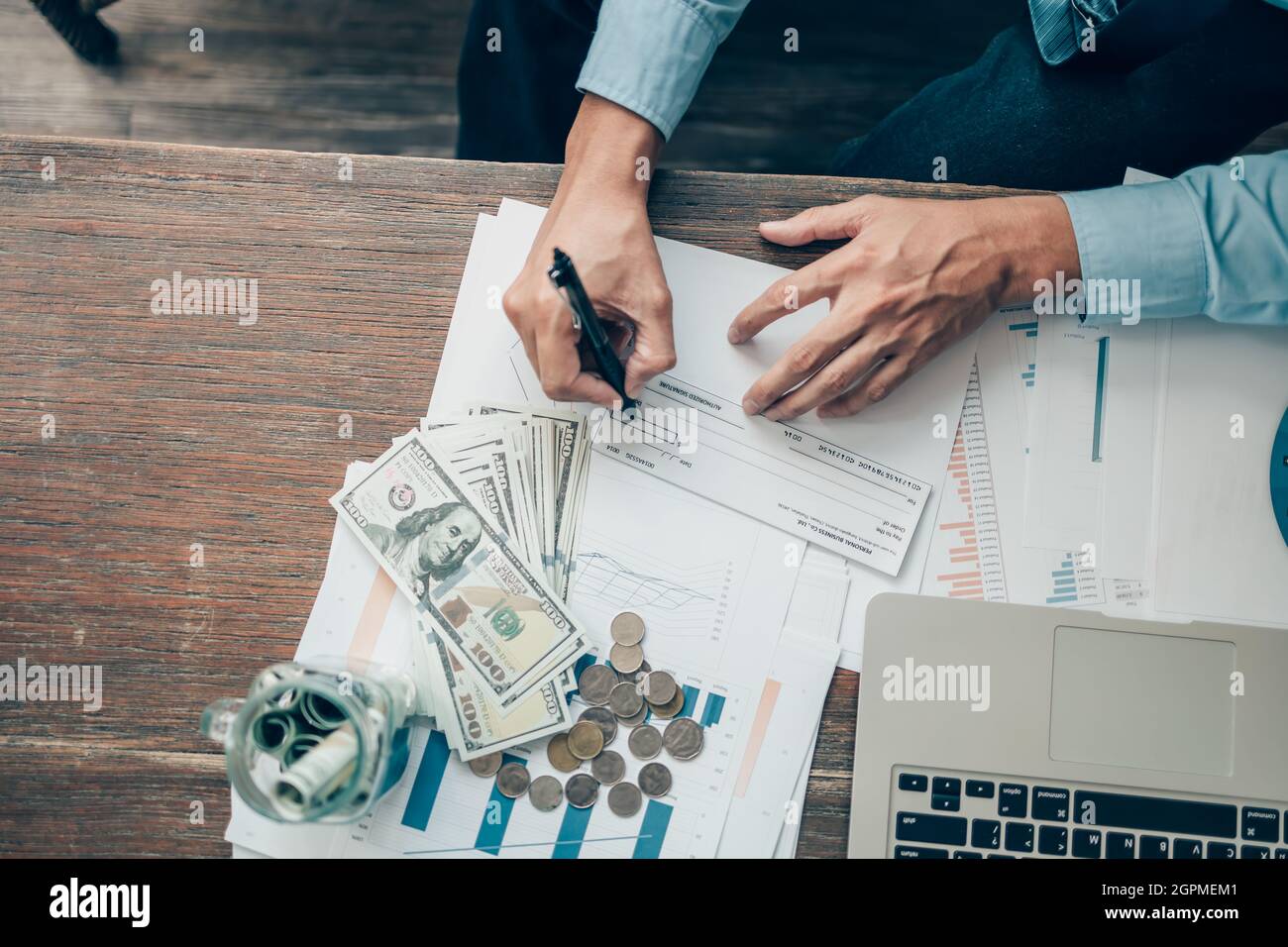 Business man hand writing and signing white blank bank check book and ...