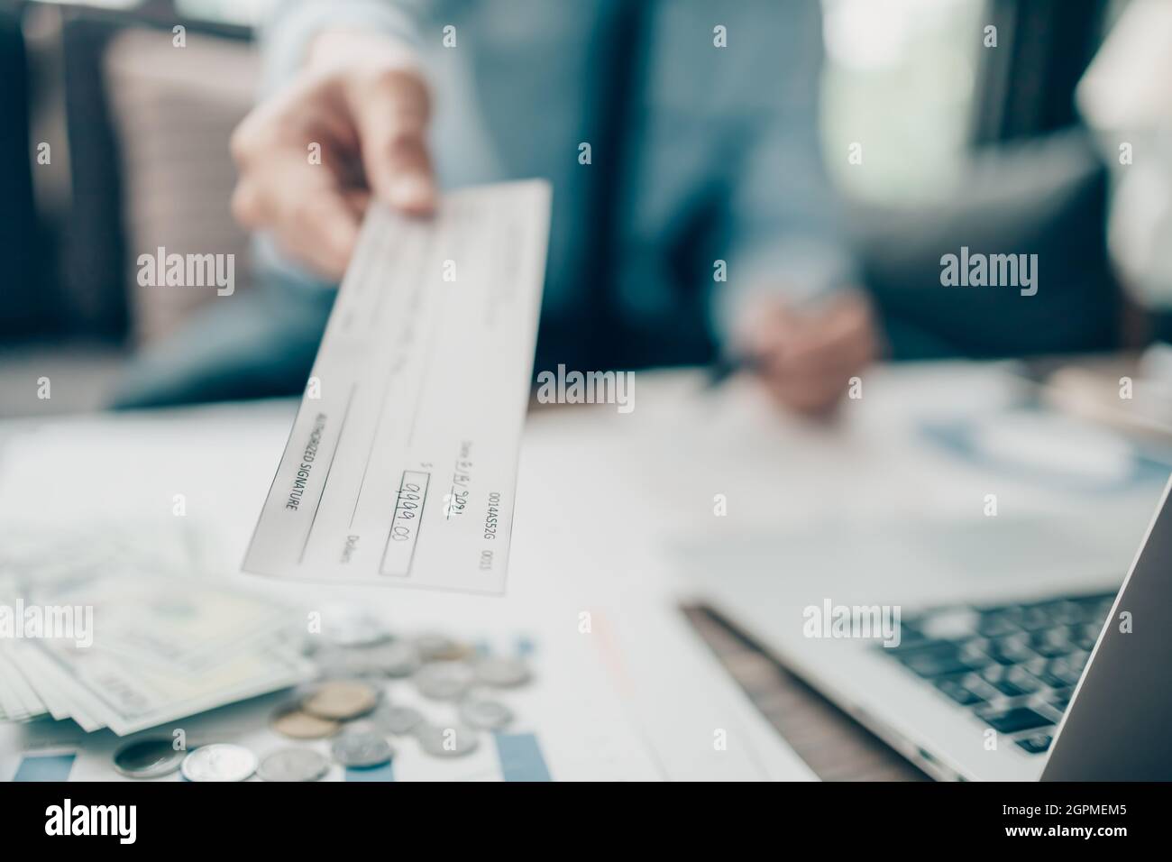 A Businessperson's hand giving cheque to customer and dollar bill, coin ...