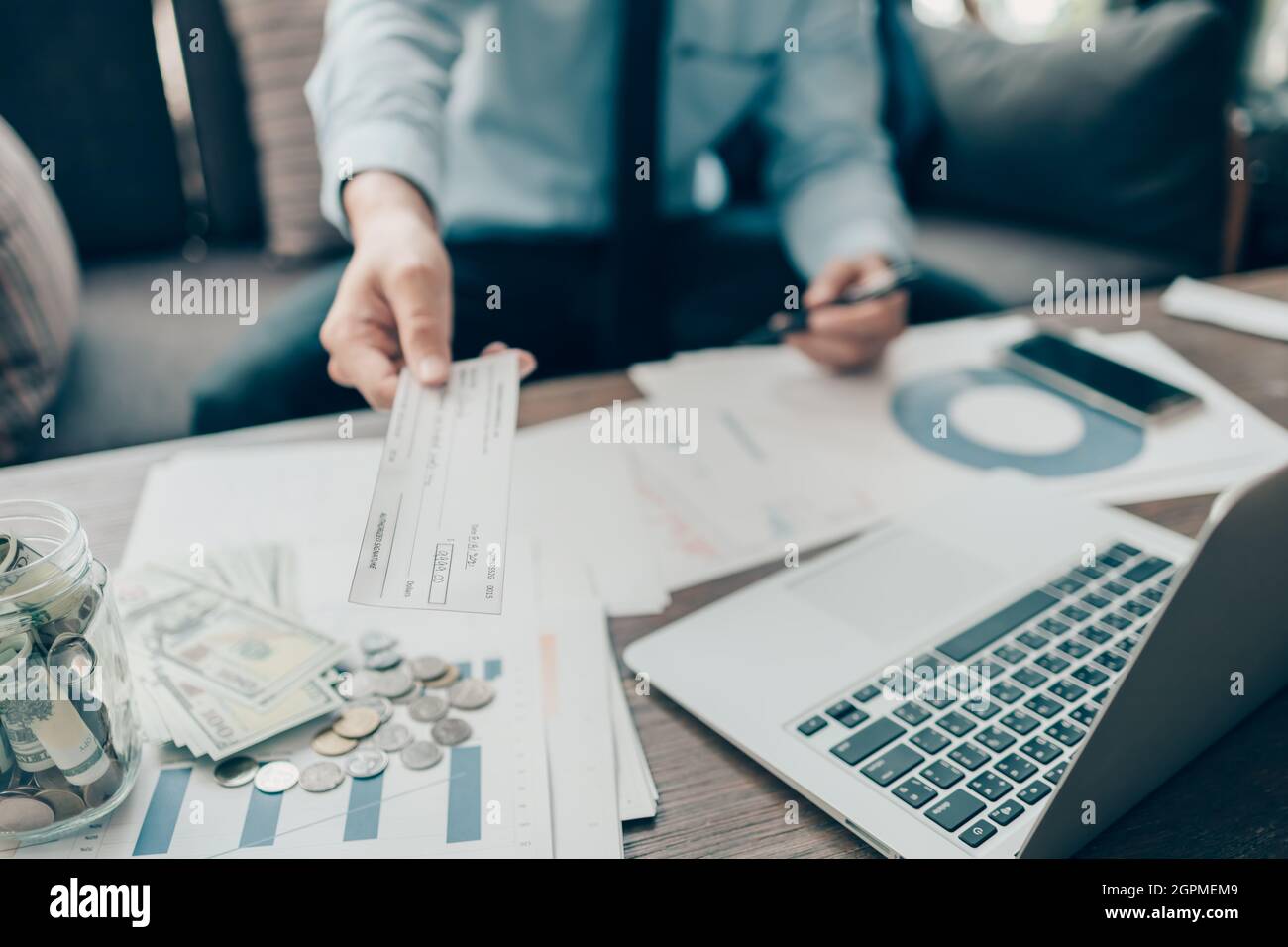 A Businessperson's hand giving cheque to customer and dollar bill, coin ...