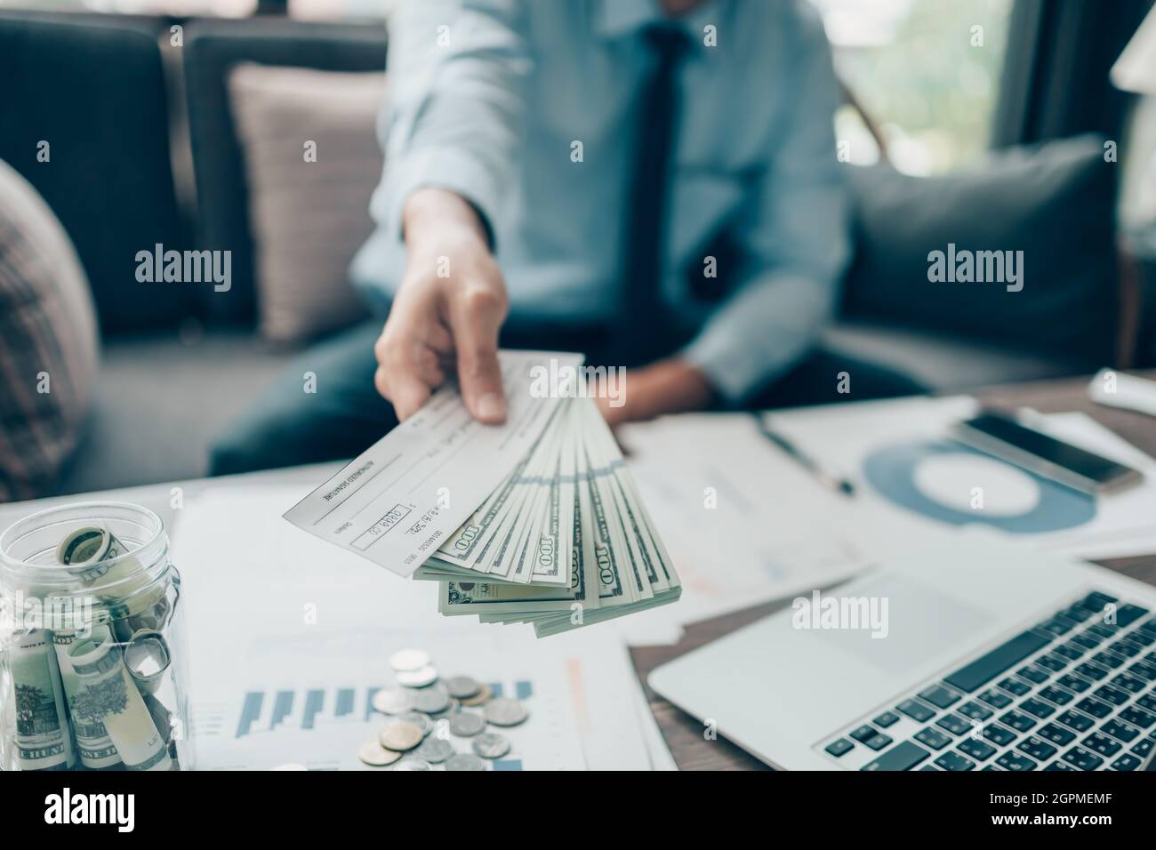 A Businessperson's hand giving cheque and dollar bill to customer and ...