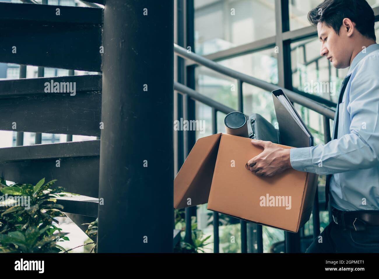 Unemployed hold cardboard box and laptop bag, dossier and drawing tube ...