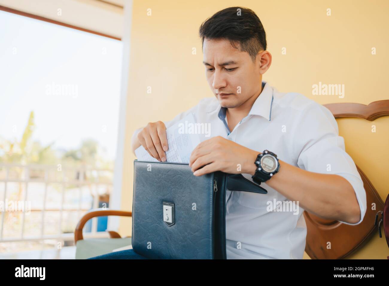 hand pulling paper data sheet out of laptop bag Stock Photo - Alamy