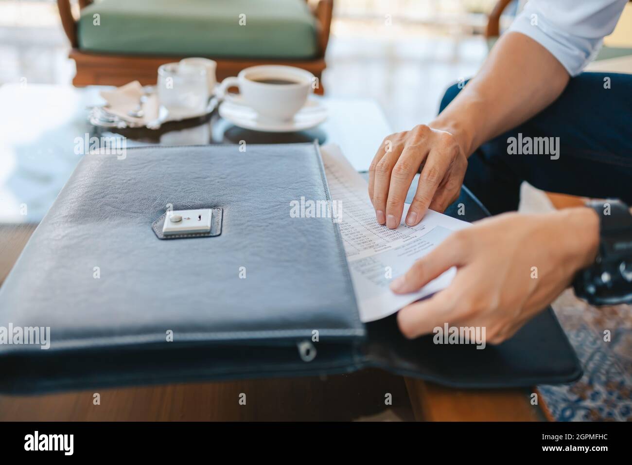 hand pulling paper data sheet out of laptop bag Stock Photo - Alamy
