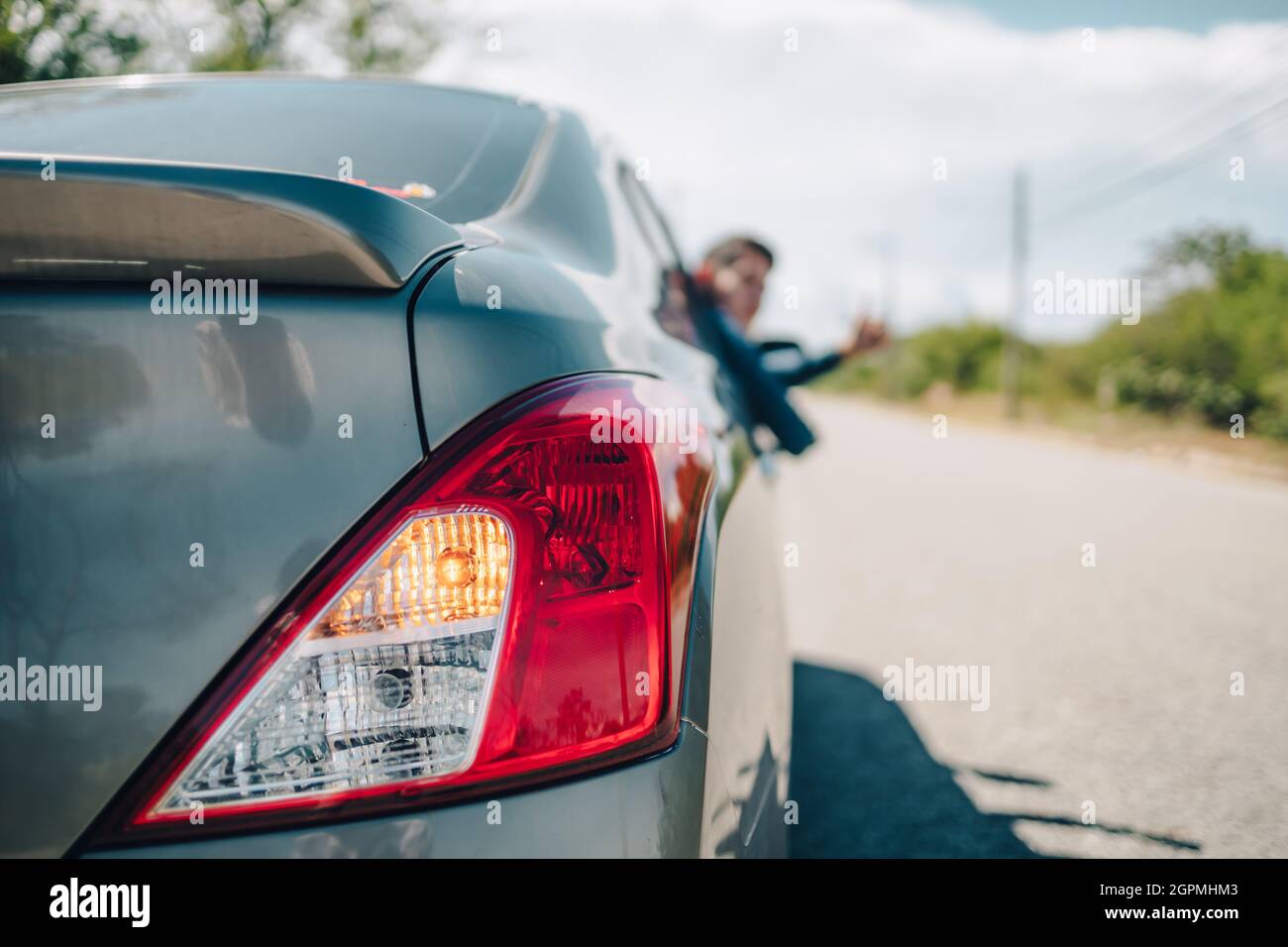 Emergency lights, taillights of a car broken on the road and hand ...