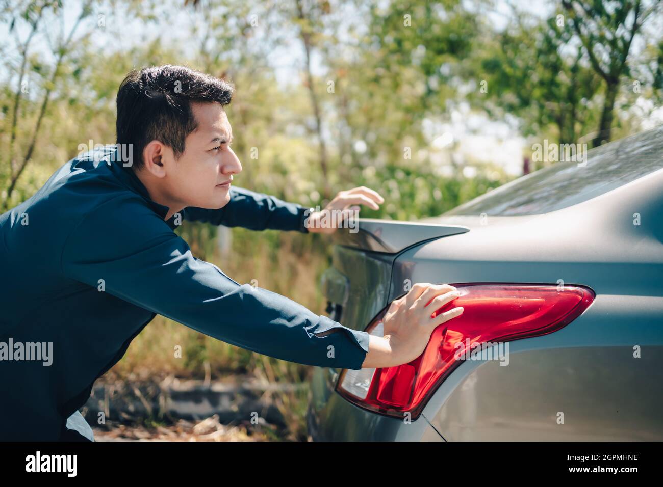 Man pushing a broken car breakdown on the road hot day. Car broken ...