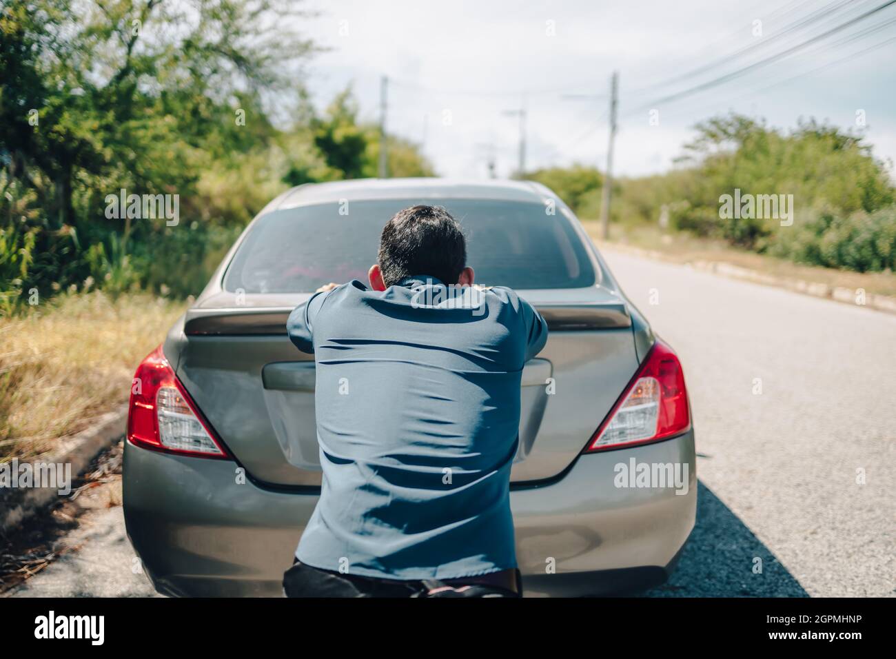 Man pushing a broken car breakdown on the road hot day. Car broken ...