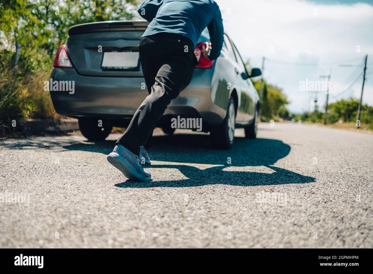 Man pushing a broken car breakdown on the road hot day. Car broken ...