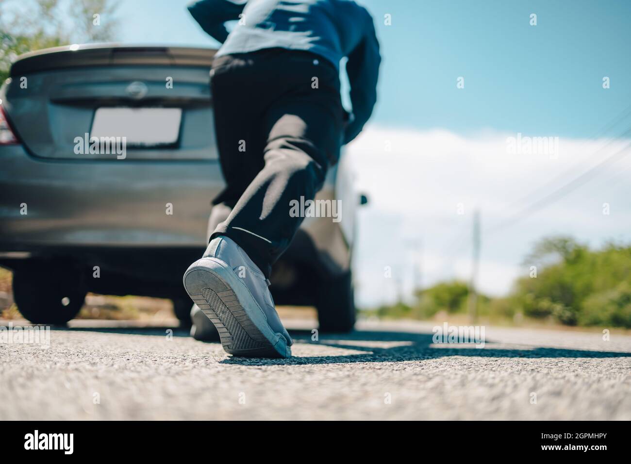 Man pushing a broken car breakdown on the road hot day. Car broken ...