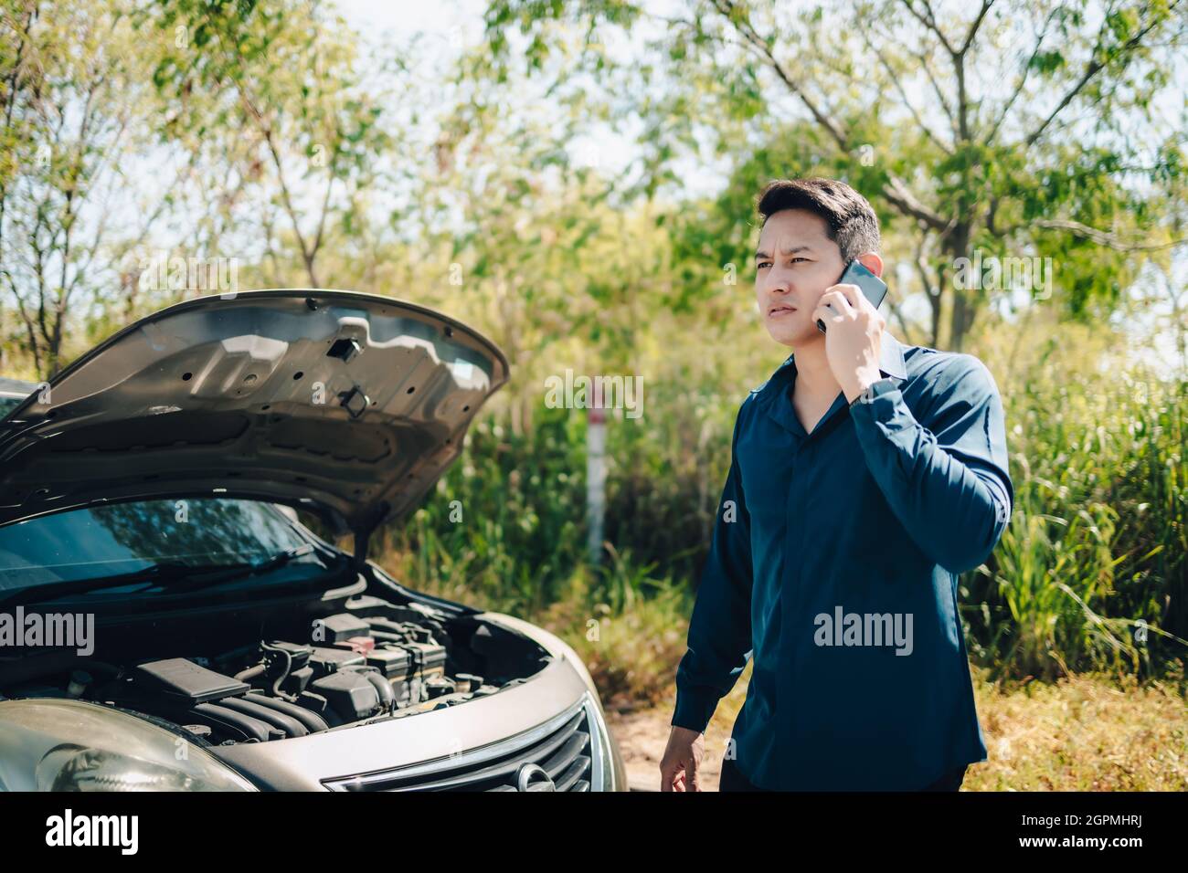 young man calling, texting for car service on roadside assistance after ...