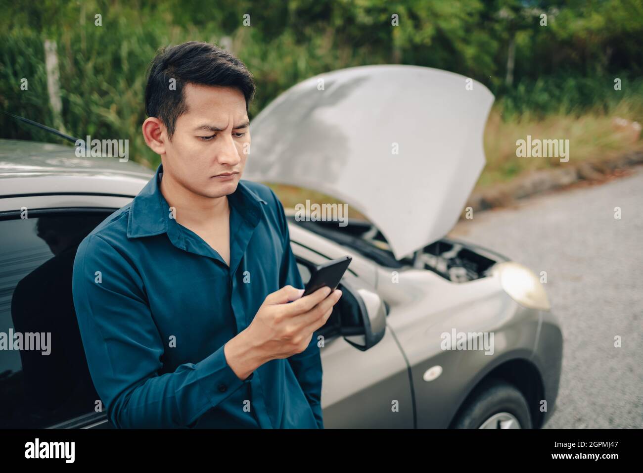 young man calling, texting for car service on roadside assistance after ...